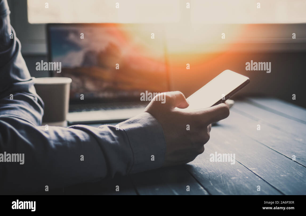 human hand using smart phone on working desk in retro color tone Stock ...