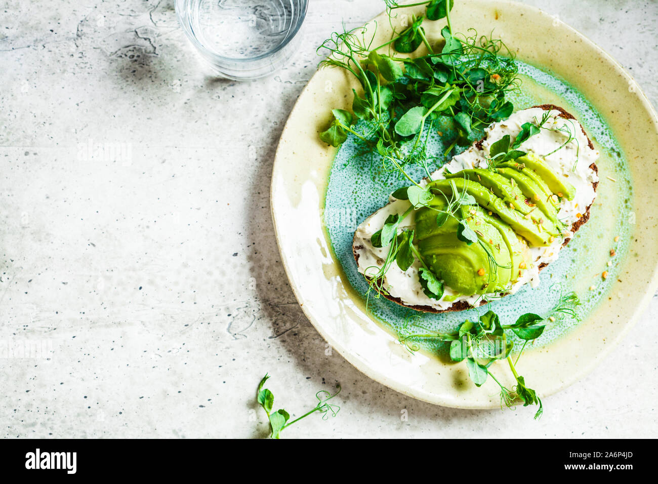 Rye bread toast with cream cheese and avocado on a beautiful plate ...