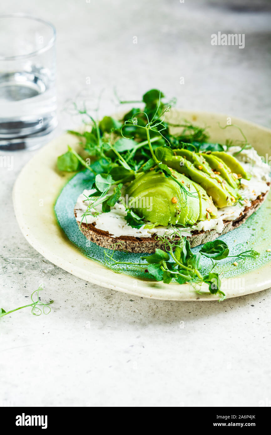 Rye bread toast with cream cheese and avocado on a beautiful plate ...