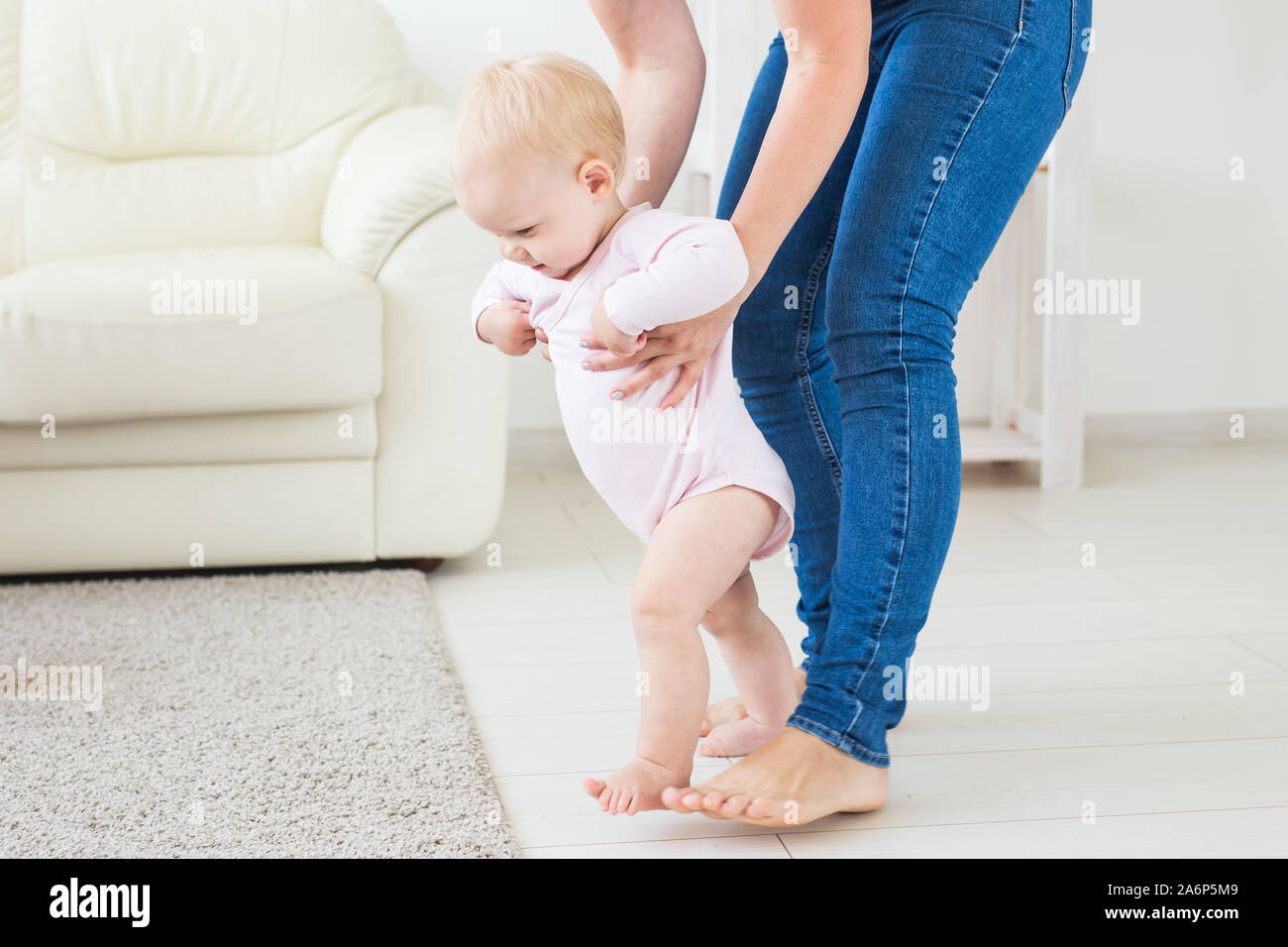 little girl first steps with the help of mom Stock Photo - Alamy