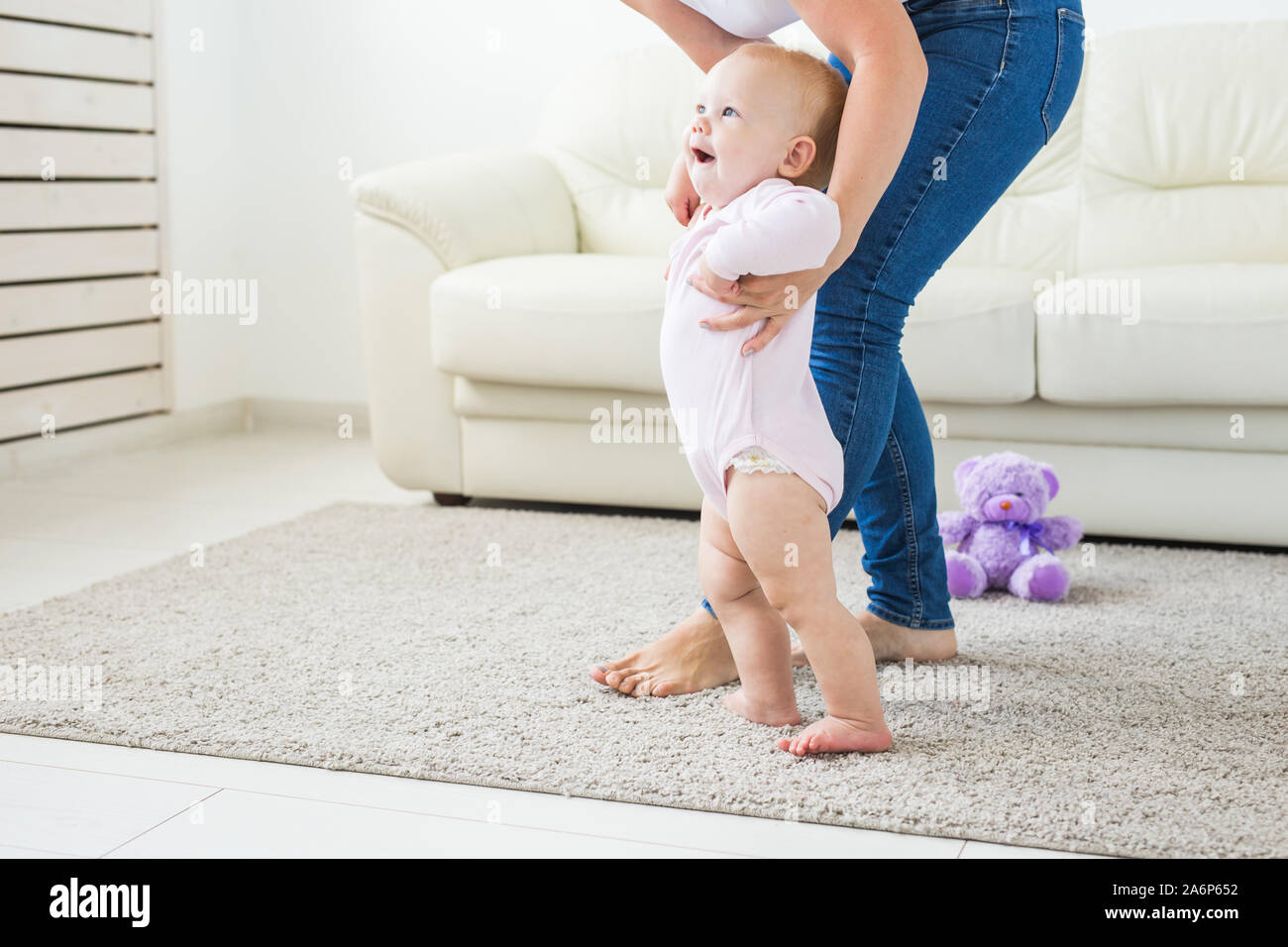 Little baby girl first steps with the help of mom Stock Photo - Alamy