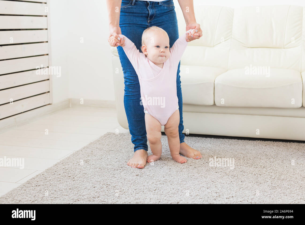Little baby girl first steps with the help of mom Stock Photo - Alamy