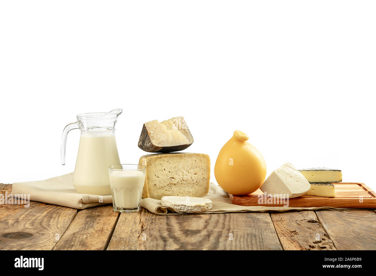 Different milk products, cheese, cream, milk on wooden table and white ...