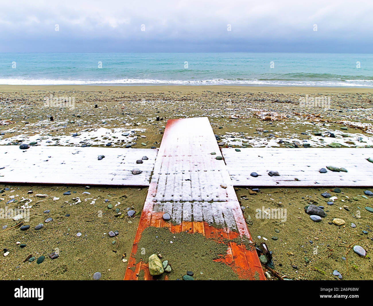 Snow covered wooden platforms forming a cross, on a beach at winter ...