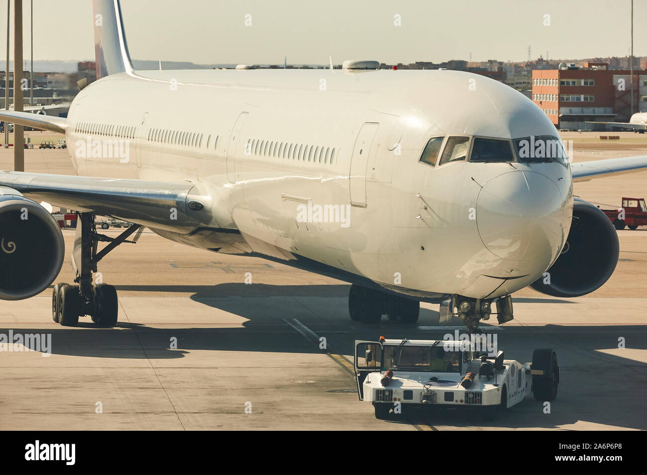 Low truck towing an aeroplane on an airport runaway. Transport Stock ...