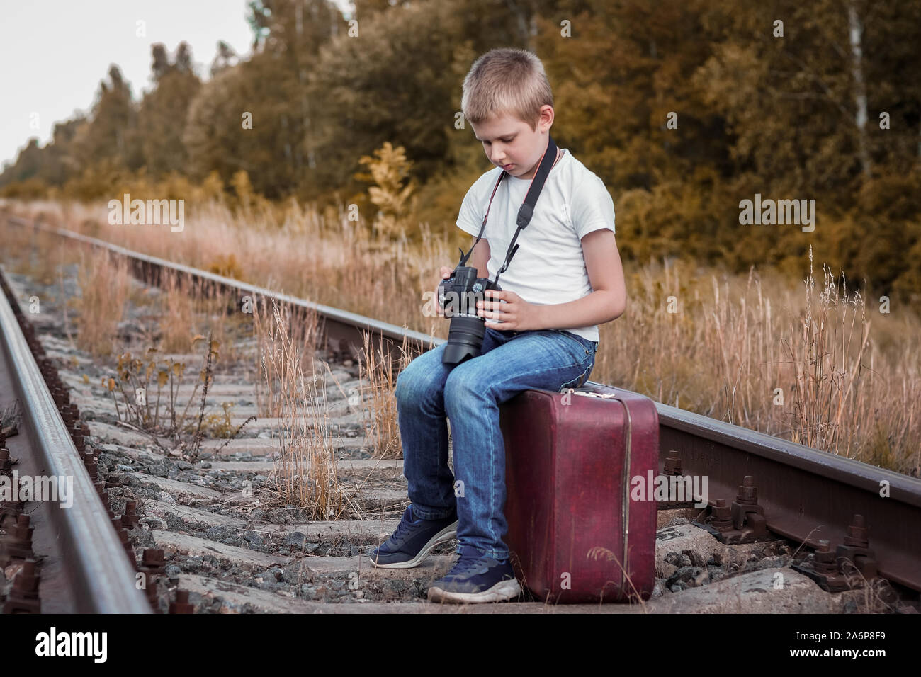 Boy with a camera on the railway in nature Stock Photo - Alamy