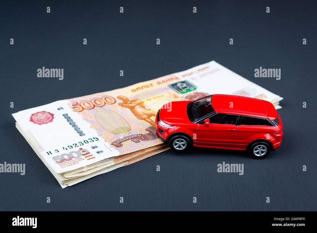 The red car is on the money, a Toy car on money Stock Photo - Alamy