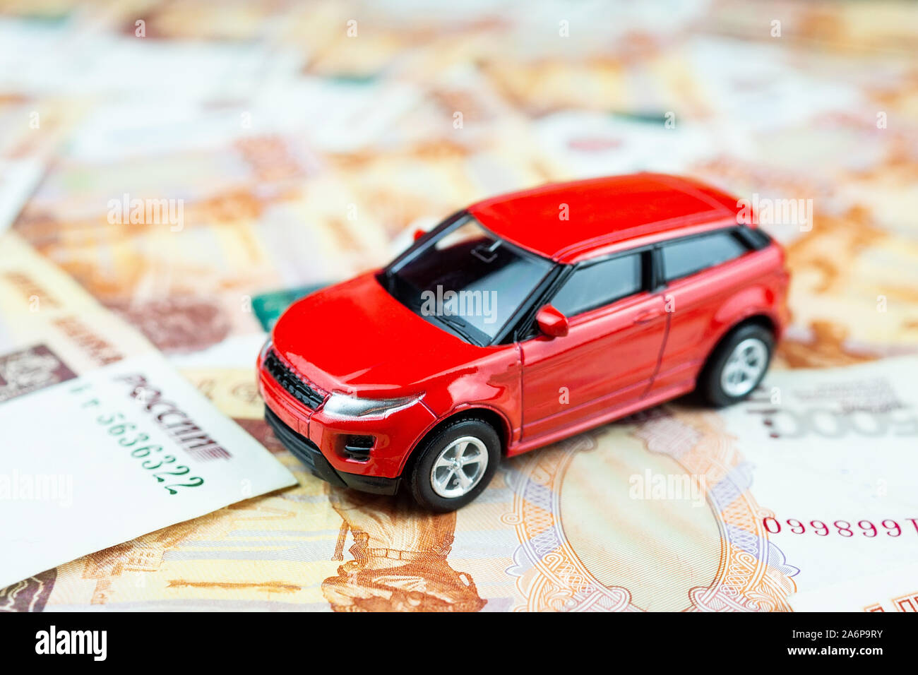 The red car is on the money, a Toy car on money Stock Photo - Alamy