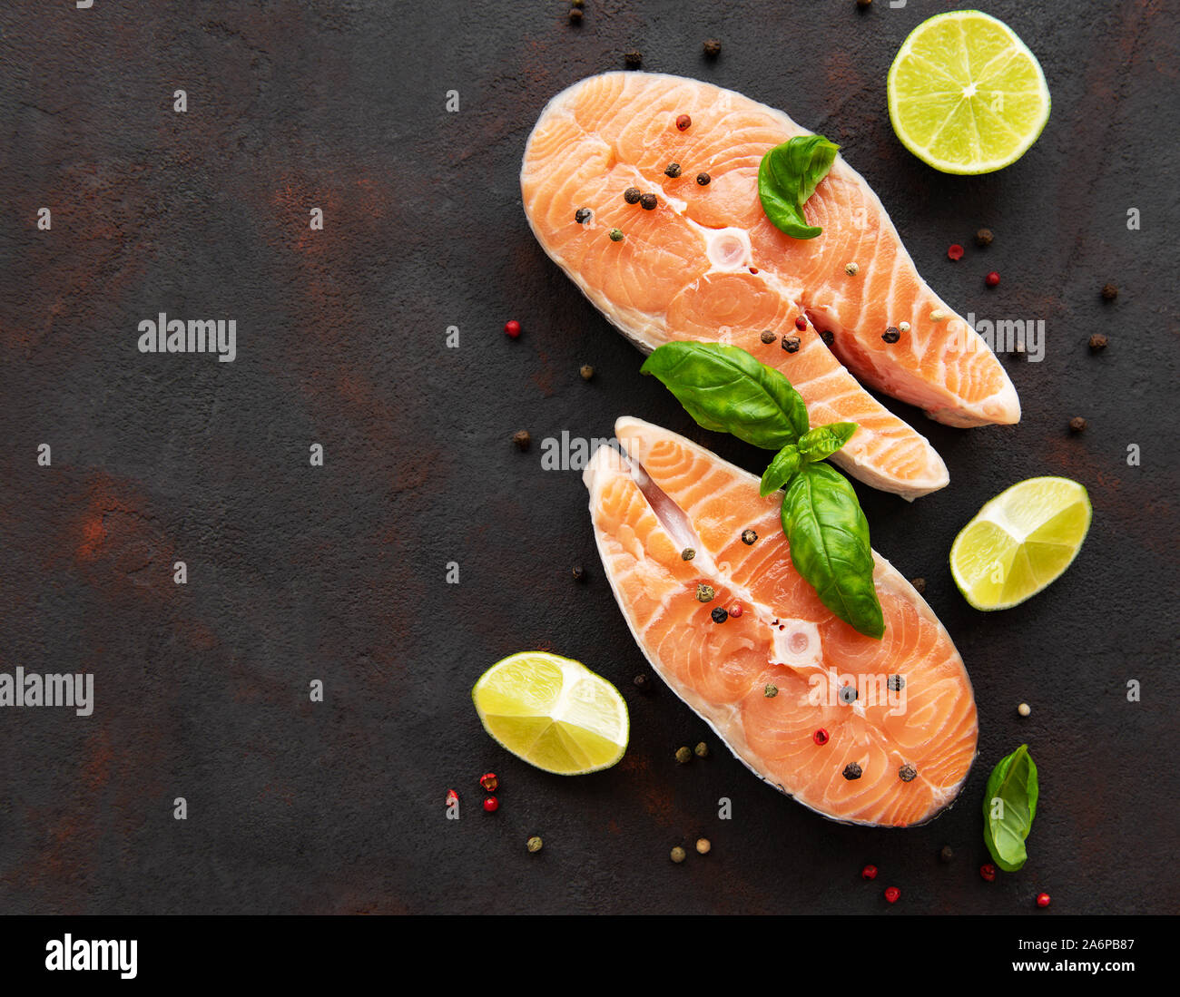 Raw salmon steaks and ingredients on a black slate board Stock Photo ...