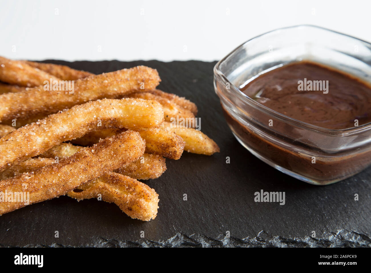 Churro stick with chocolate on black granite board Stock Photo - Alamy