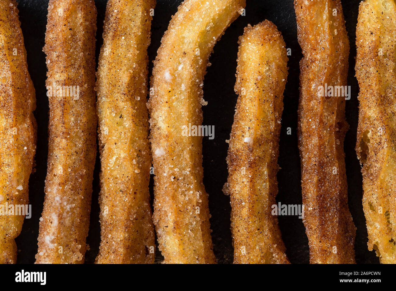 Churro sticks on black background Stock Photo - Alamy
