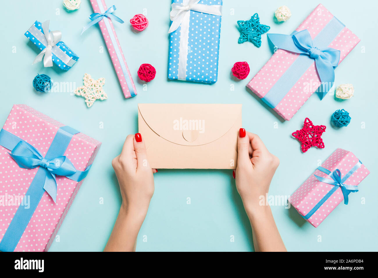 Top view of woman holding an envelope on blue background made of ...