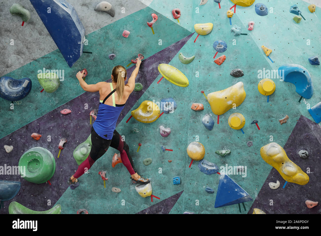 Back view of young active female hanging on climbing equipment Stock ...