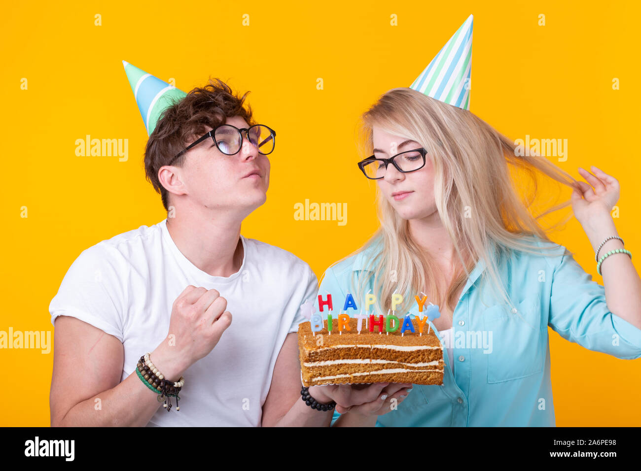 Cheerful young couple charming guy and cute girl in paper hats make ...