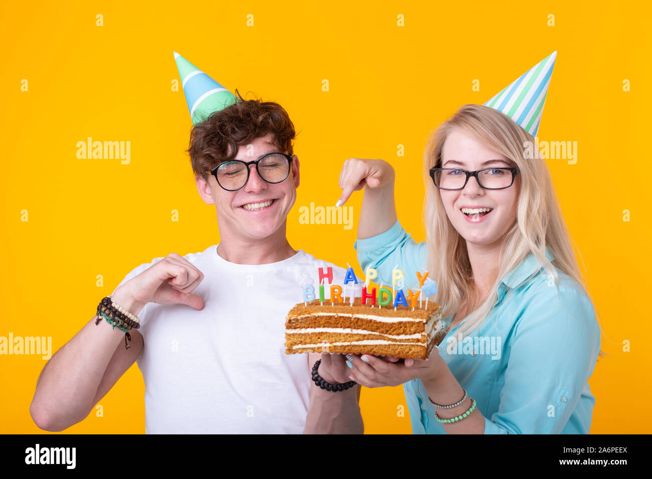 Cheerful young couple charming guy and cute girl in paper hats make ...