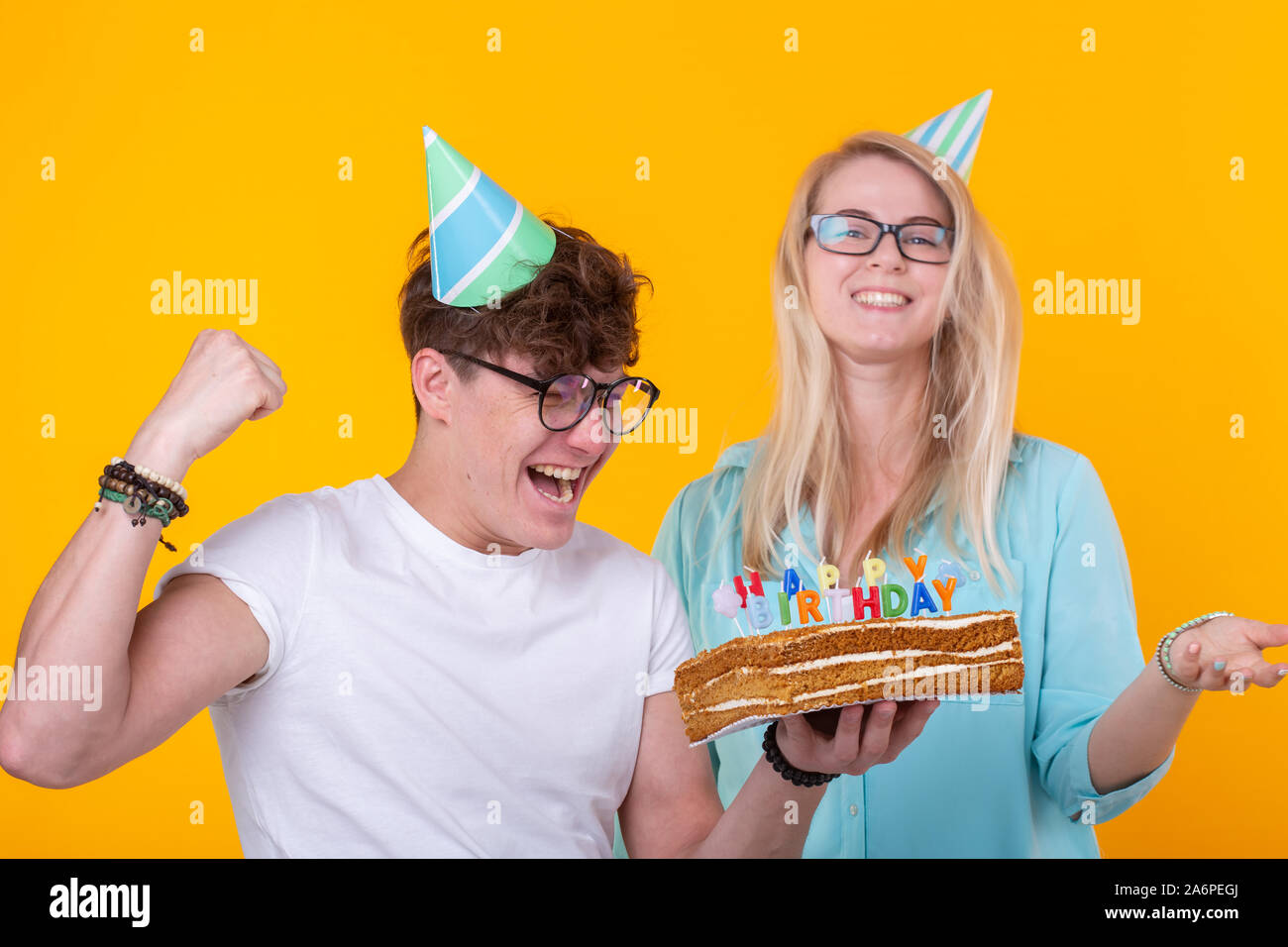 Cheerful young couple charming guy and cute girl in paper hats make ...