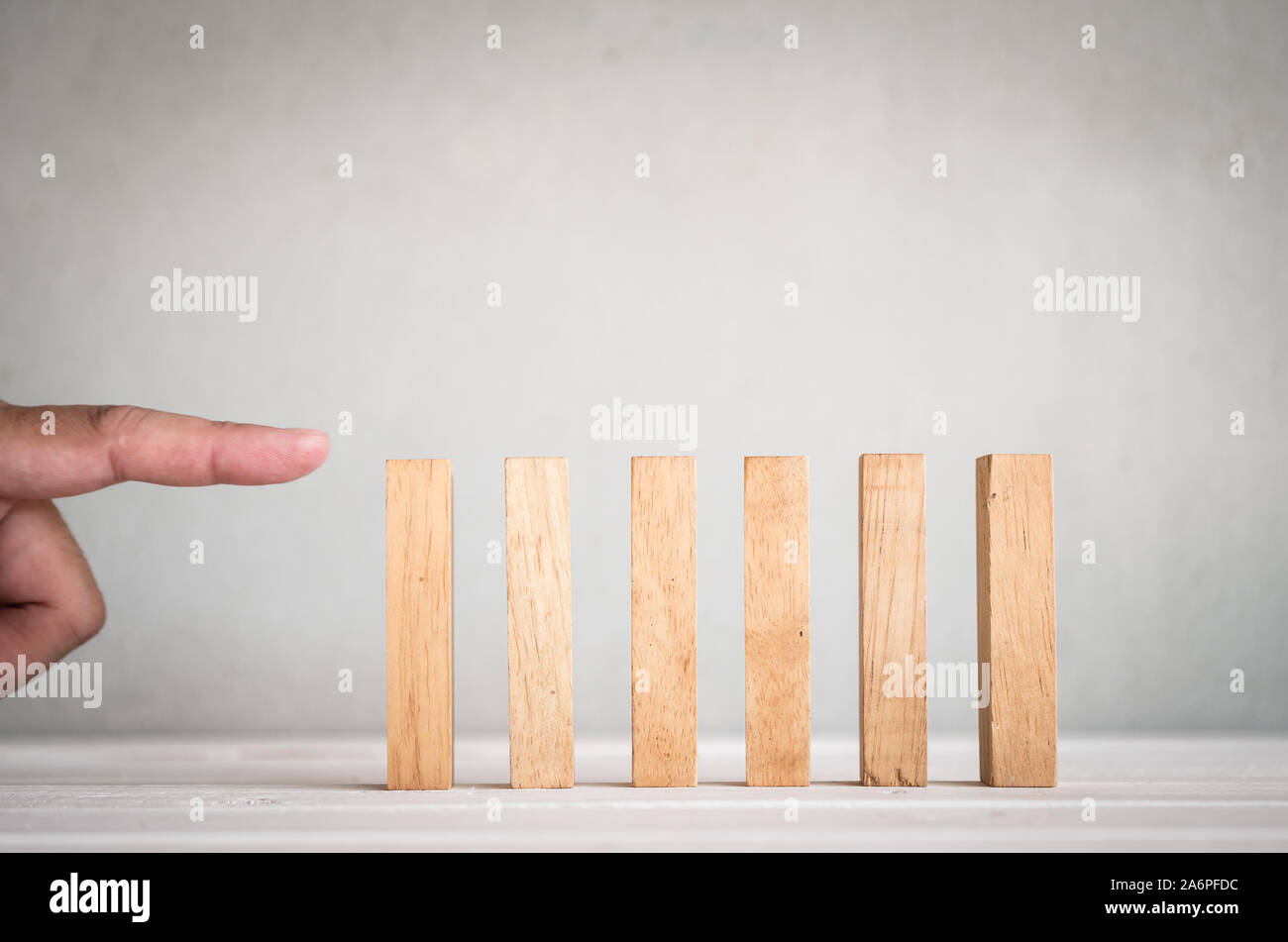 part of human finger push wooden domino on table Stock Photo - Alamy