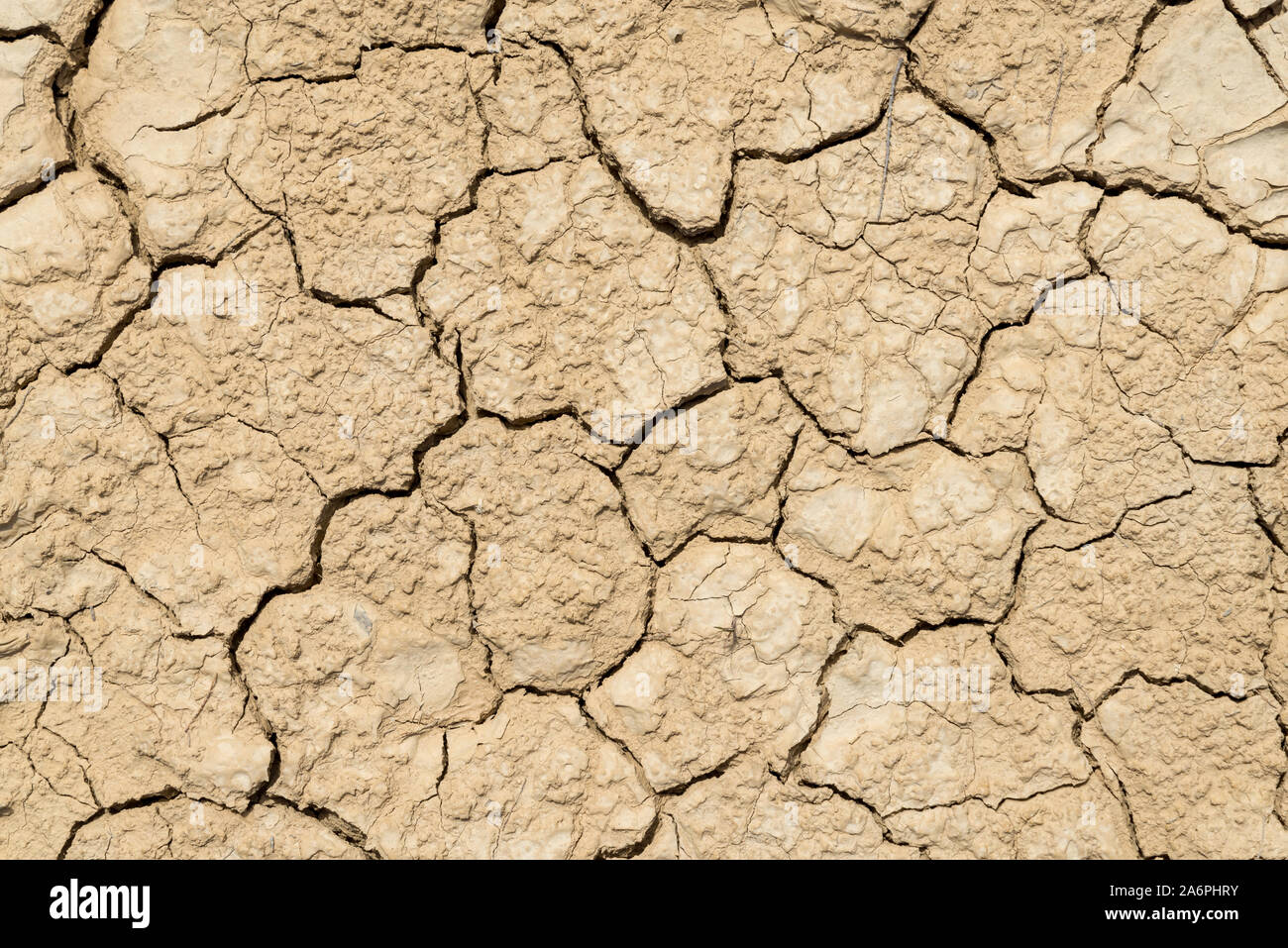 Clay sandy earth parched and cracked Stock Photo - Alamy