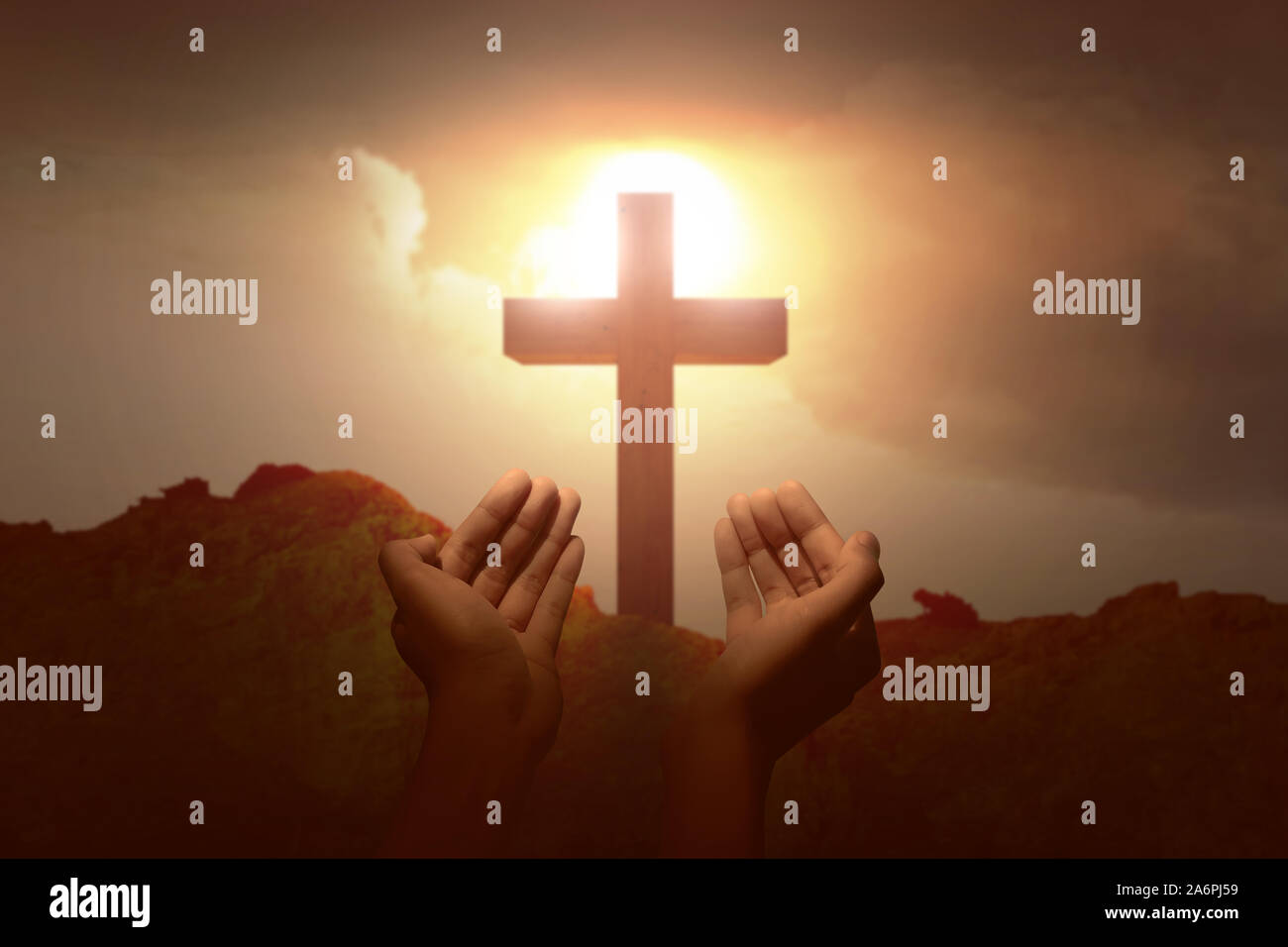 A human raised hands praying with to god with a sunset sky background ...