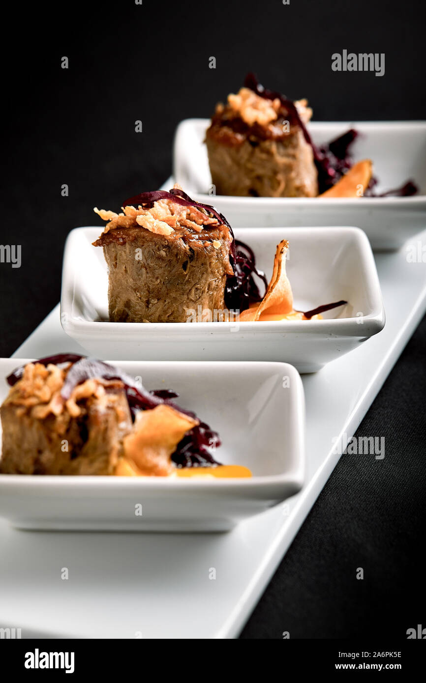 Canapes beef rolls with pumpkin sauce, on white plates Stock Photo - Alamy
