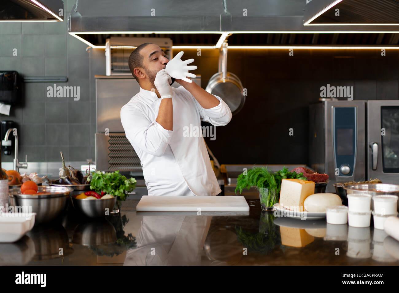 young attractive male cook blows up his protective glove jokes and has ...