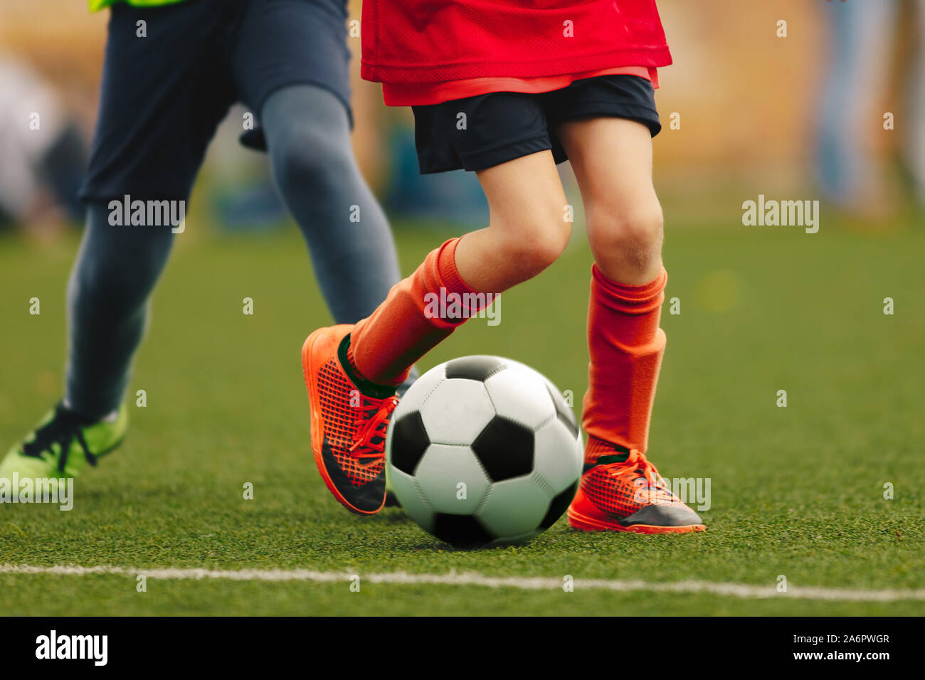 Close-up of child with soccer ball running on grass. Kids kicking ...