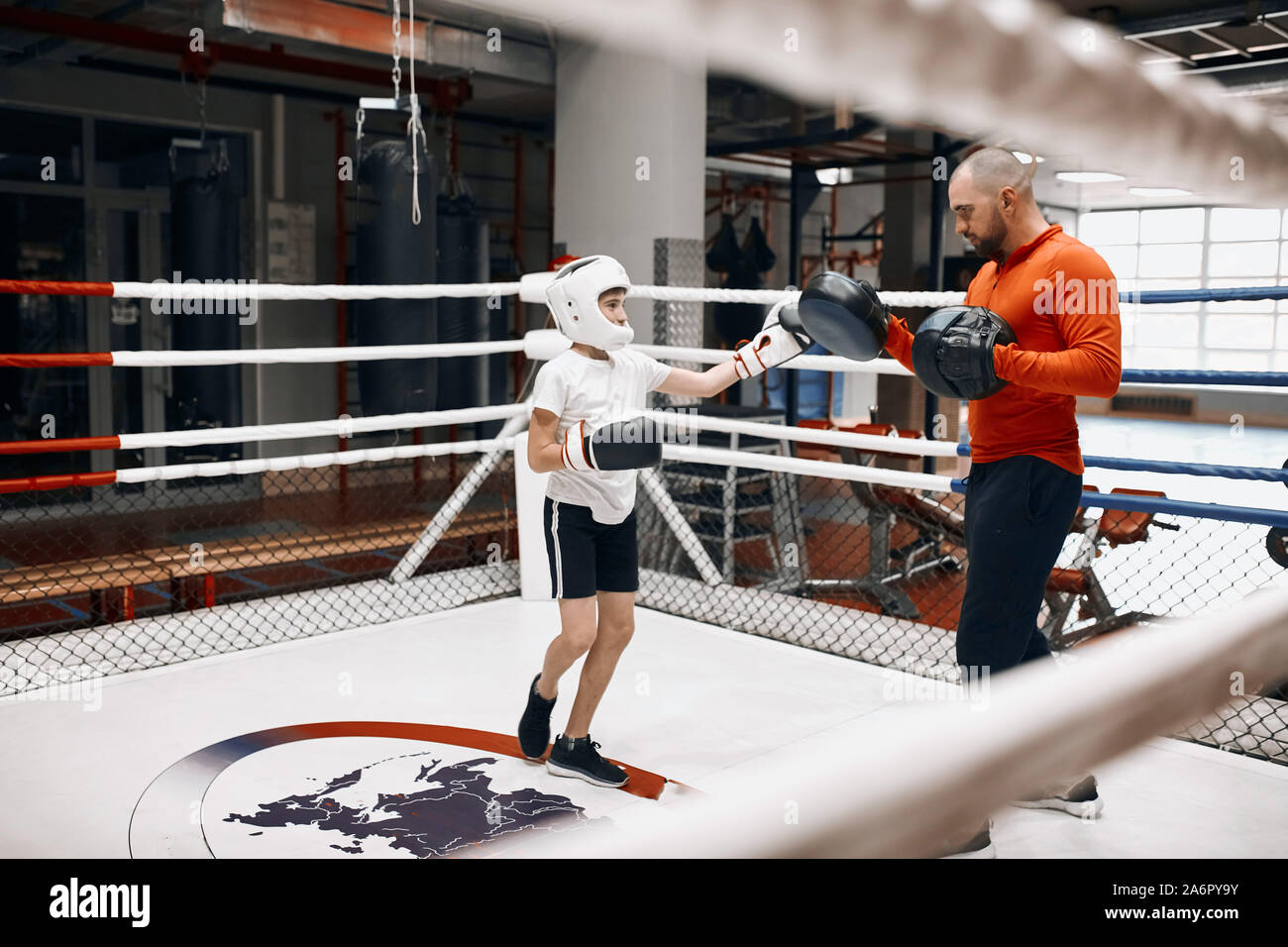 kid boxing with his personal coach, preparing for competition ...