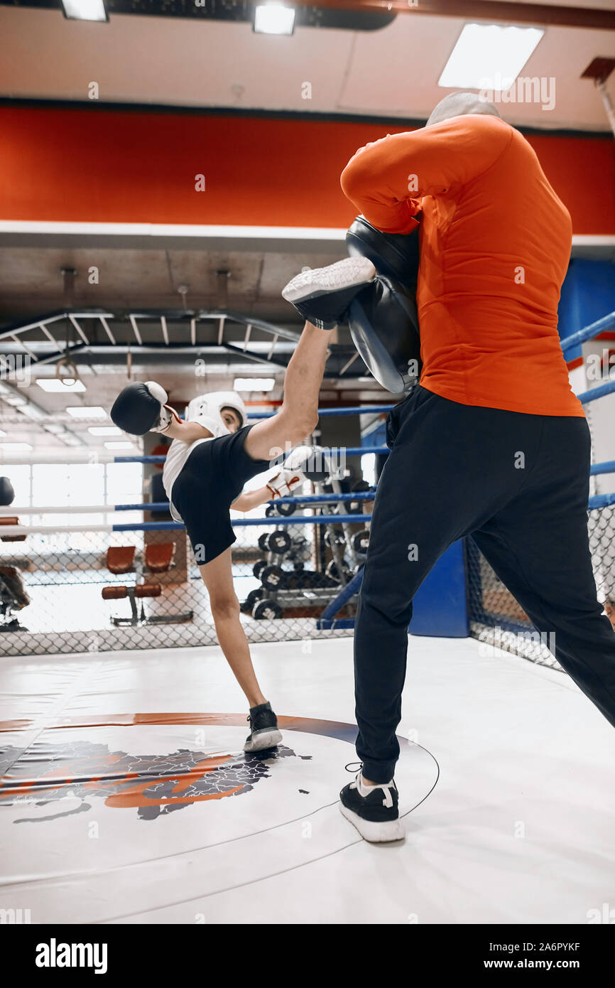 strong little boy punching his trainer, full length photo. boy ...
