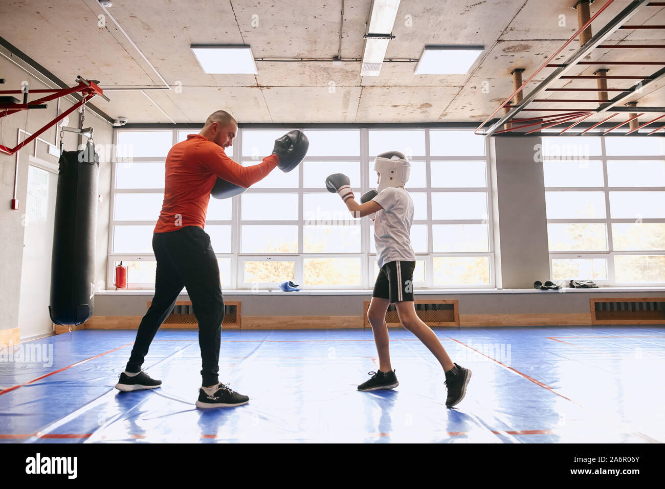 boy developing striking skills, strength training process. full length ...
