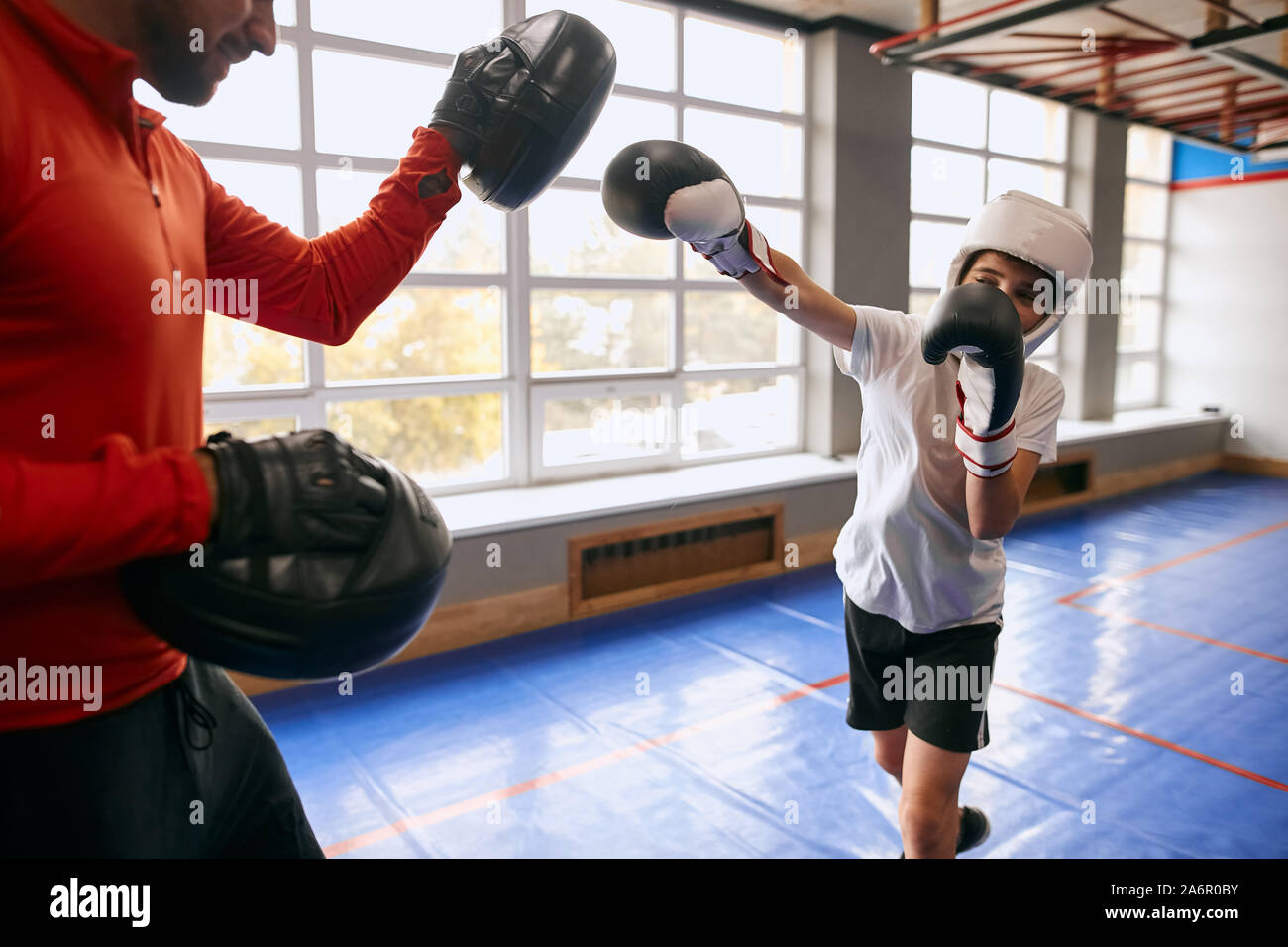 kid trying to hit his opponent during workout, boy with stretched arm ...
