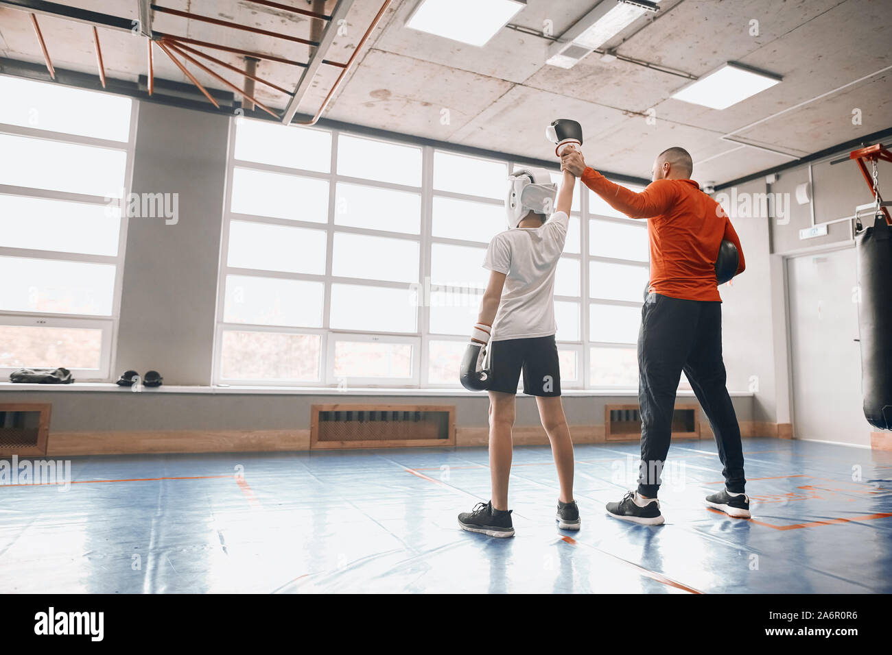coach raising the boy's arm, man and kid are rejoicing at victory ...