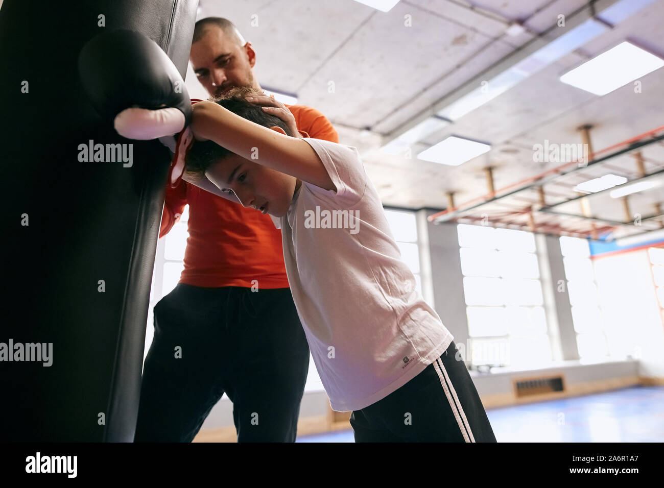 unhappy sad depressed boy leaning on heavy bag, close up photo. boxer ...