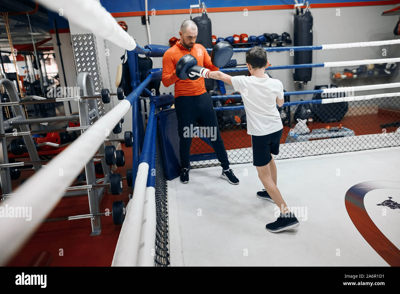 little boy concentrated on working out with coach, full length photo ...
