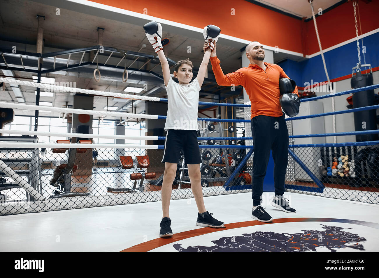 cheerful happy coach holding the winner's arm in the ring. trainer ...