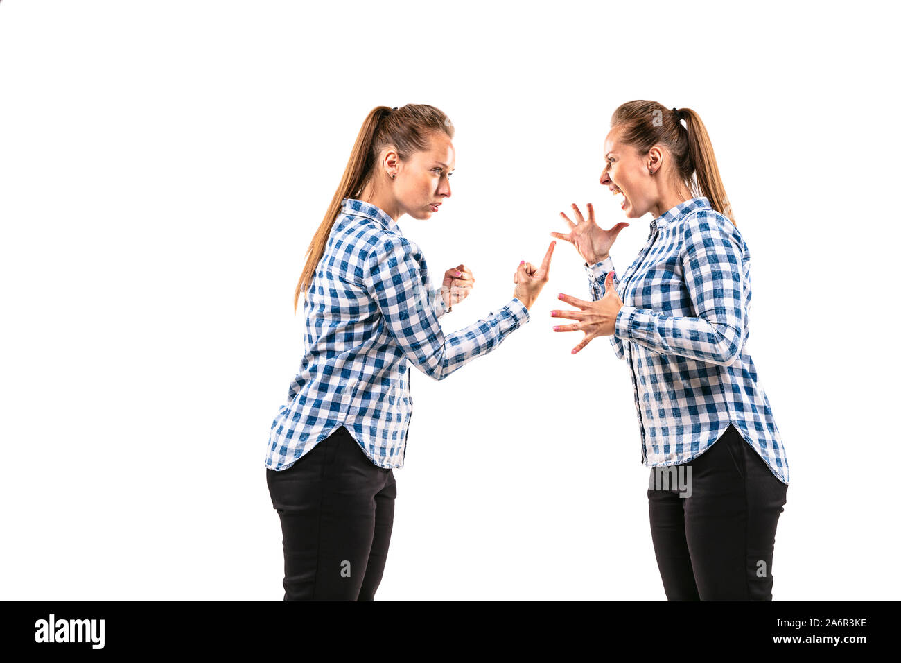 Young handsome woman arguing with herself on white studio background ...