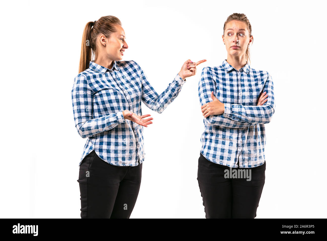 Young handsome woman arguing with herself on white studio background ...