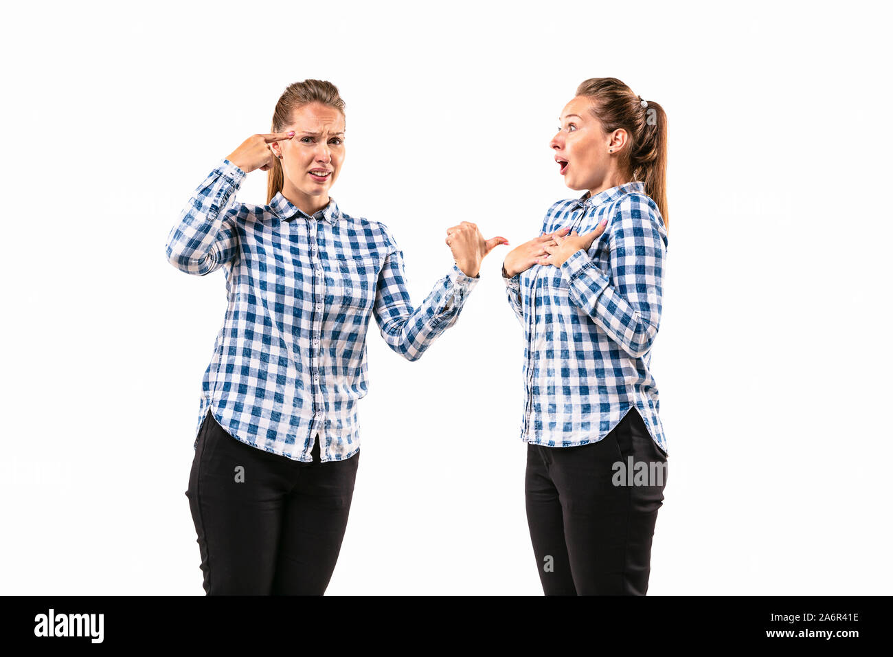 Young handsome woman arguing with herself on white studio background ...
