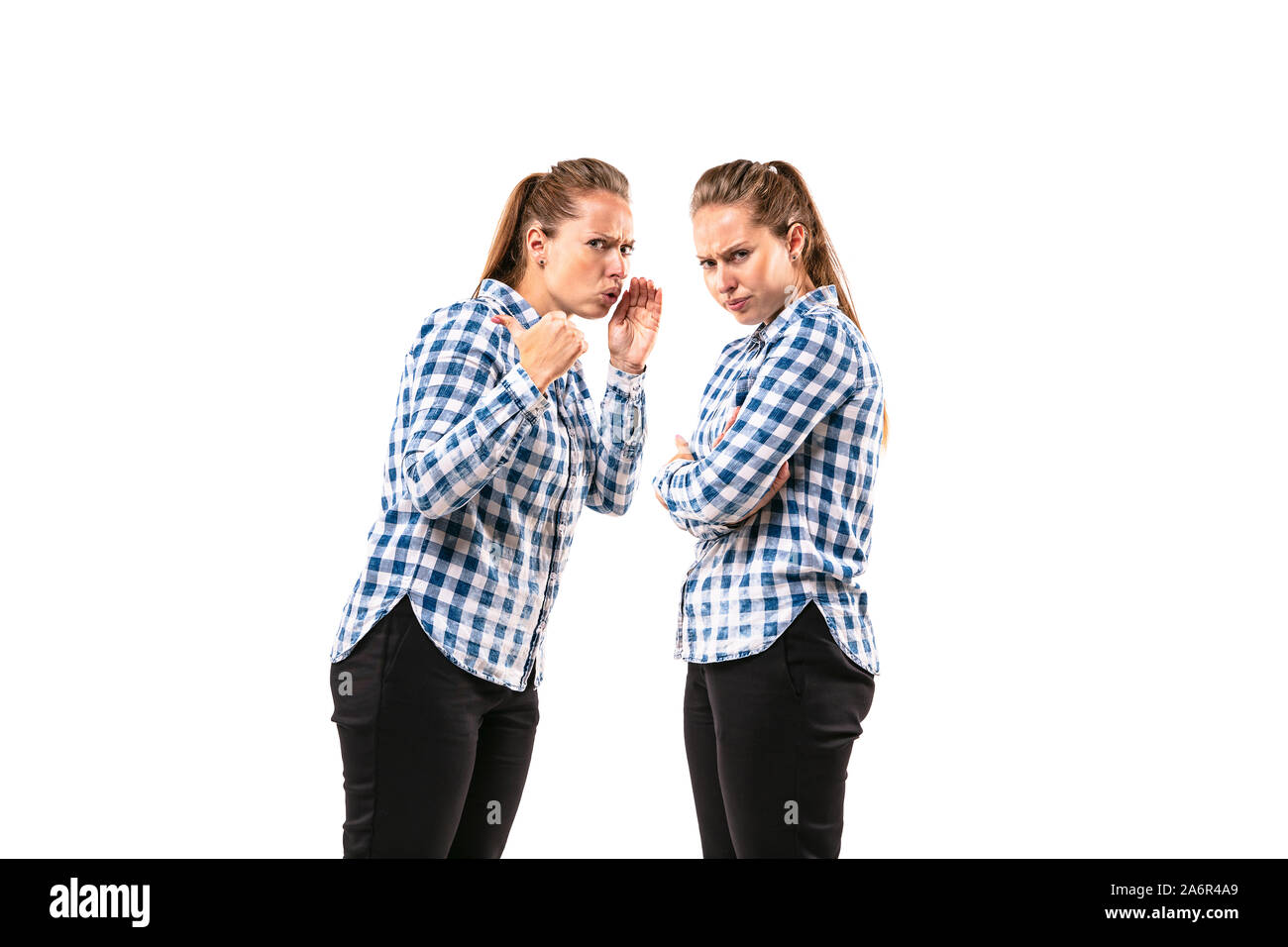 Young handsome woman arguing with herself on white studio background ...