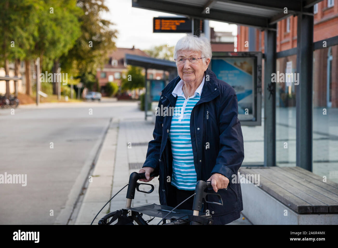 Over 90 years old active senior lady waiting for the bus at the bus ...