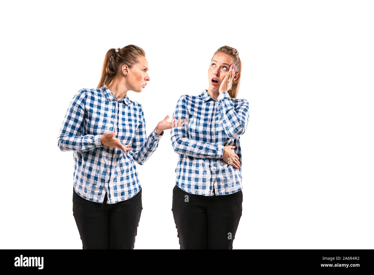 Young handsome woman arguing with herself on white studio background ...