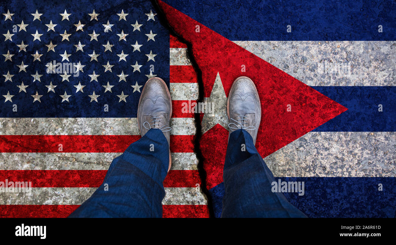 Business man stands on cracked flags of USA and Cuba. Political concept ...