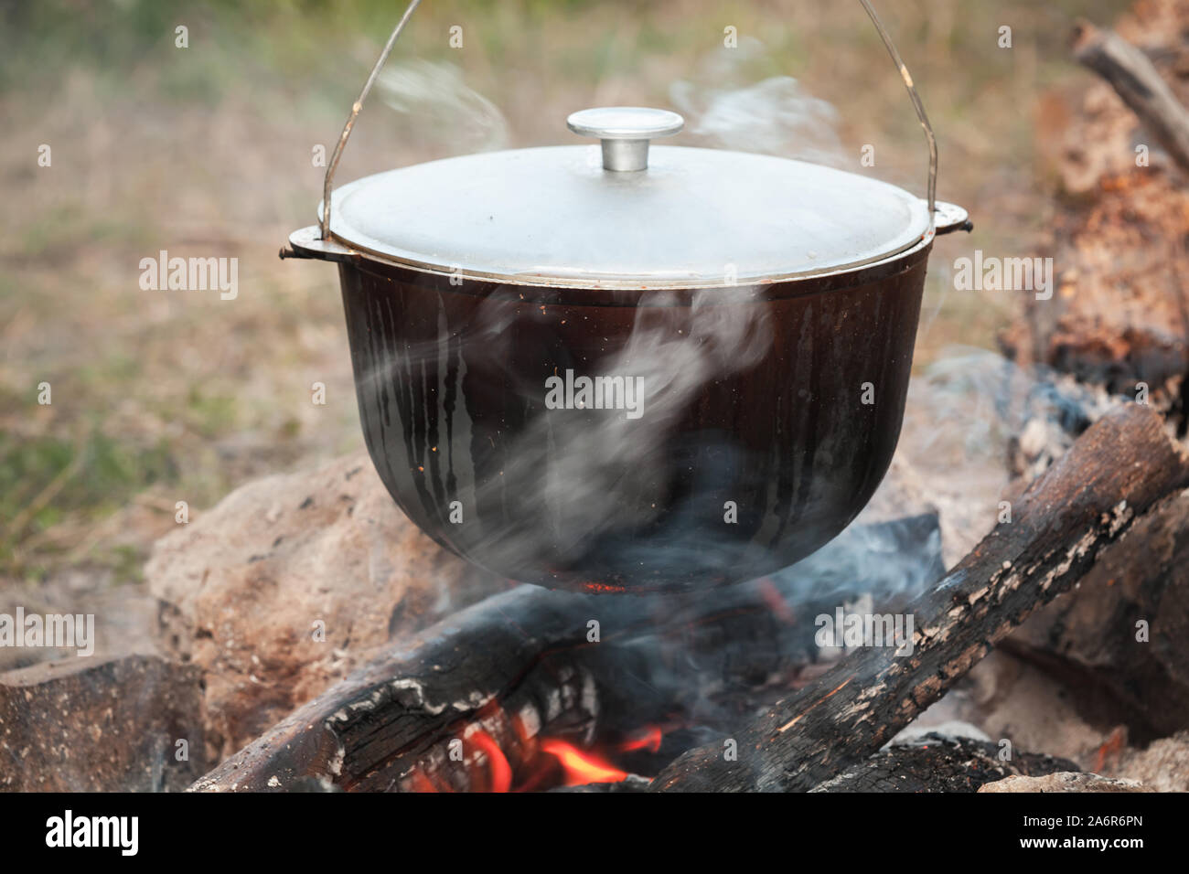 Preparing of a tourists soup on open fire, camping meal. Bonfire and ...