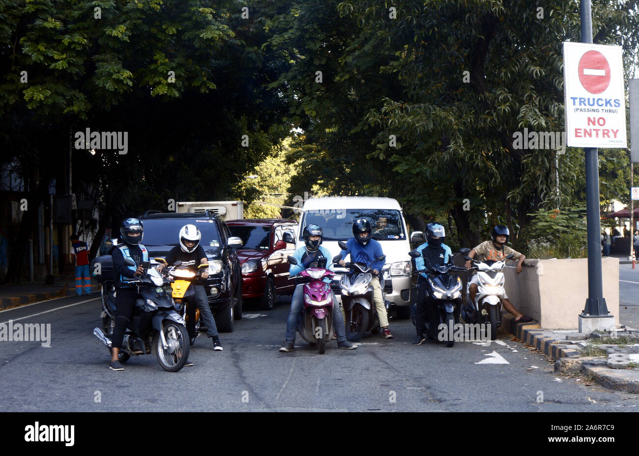 PASIG CITY, PHILIPPINES – OCTOBER 15, 2019: Motorcycle drivers wait for ...