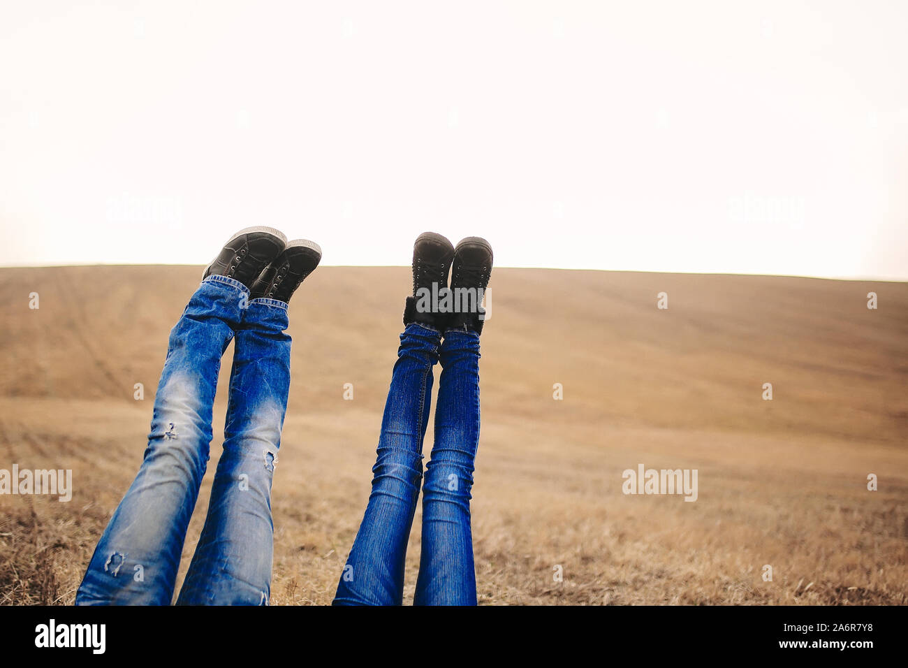 A women and man feet raised up high in the air. Shoot in field on ...