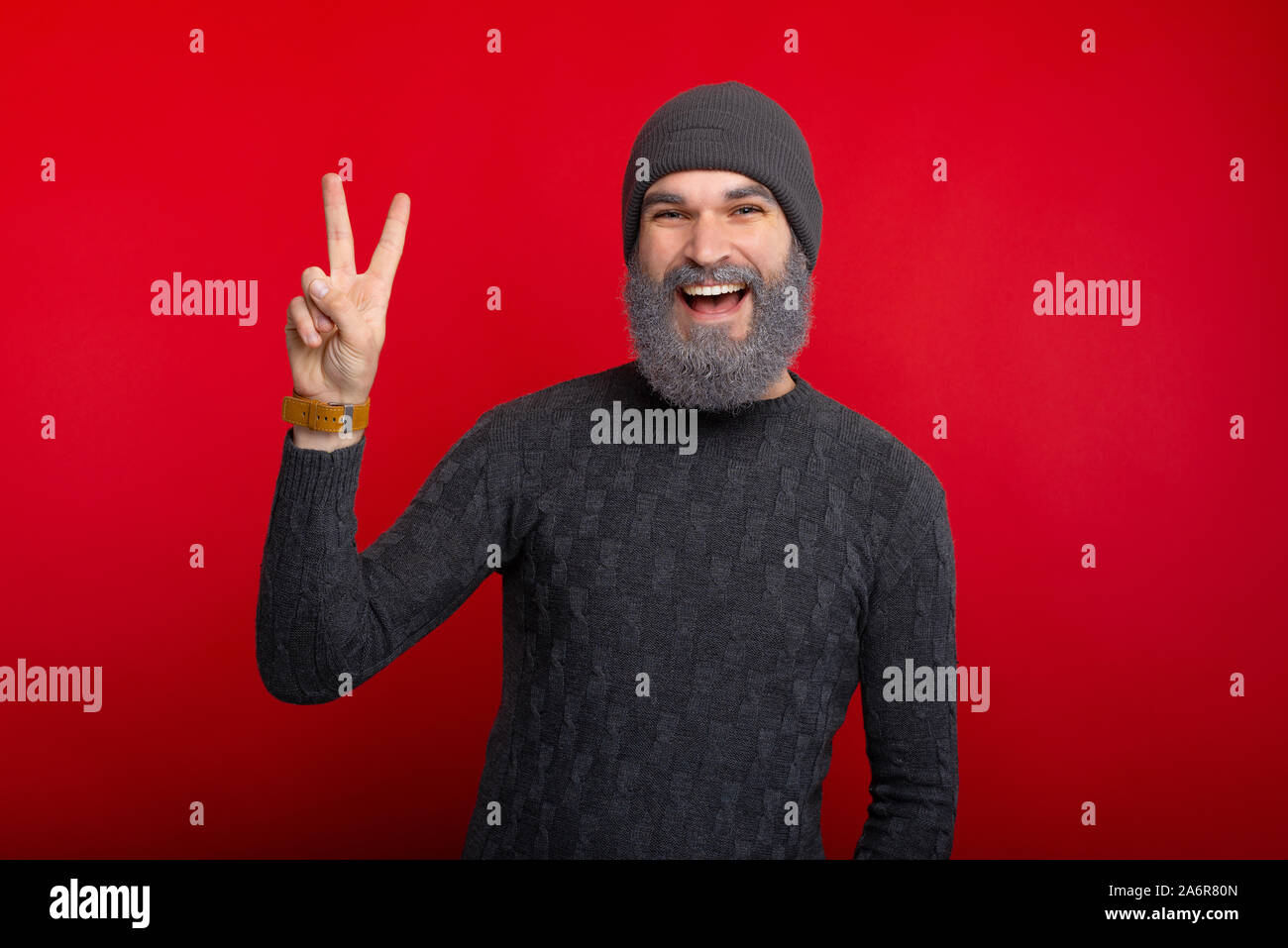 Cheerful young man with white beard showing PEACE gesture Stock Photo ...