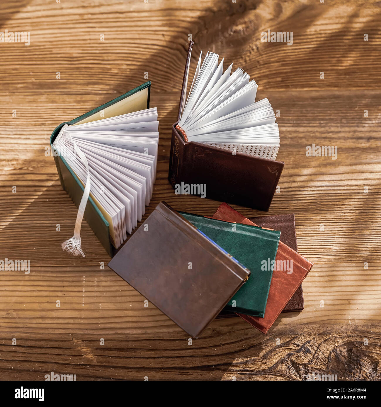 Books of different colors, top view from the butt, wooden background ...