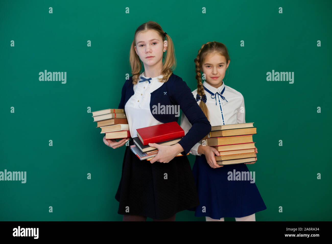 two schoolgirl girls with books in class education Stock Photo - Alamy
