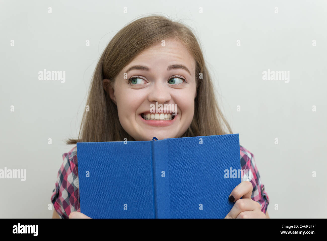 Smiling young caucasian girl woman, reading a book Stock Photo - Alamy
