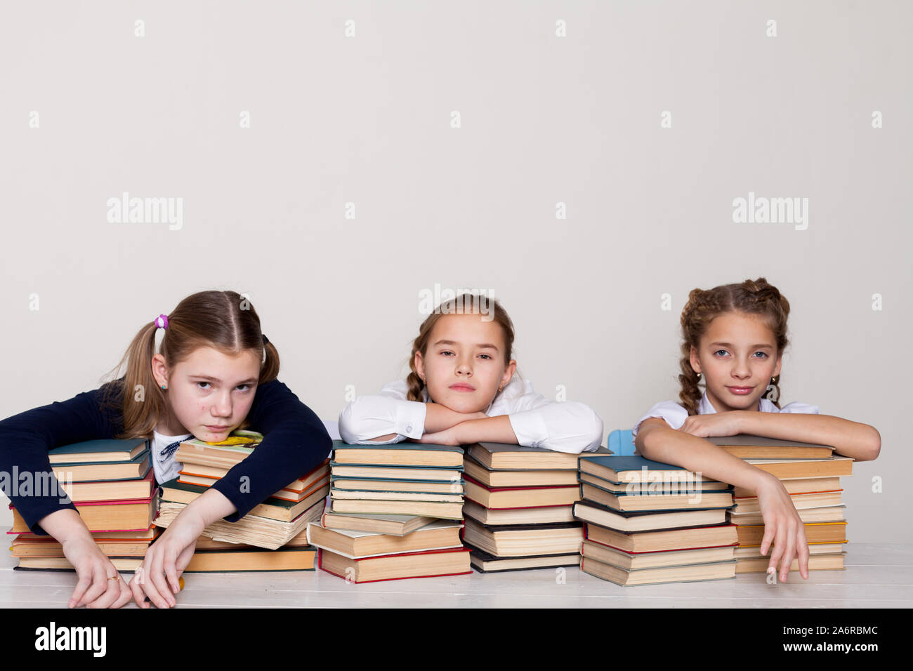 three schoolgirl girls at the desk with books in class Stock Photo - Alamy