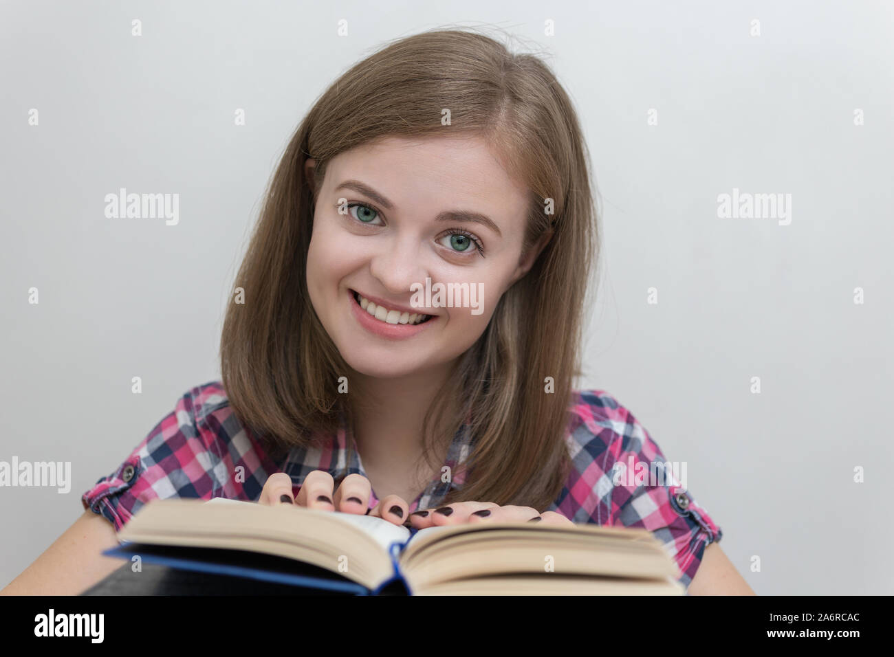 Smiling young caucasian girl woman, reading a book Stock Photo - Alamy